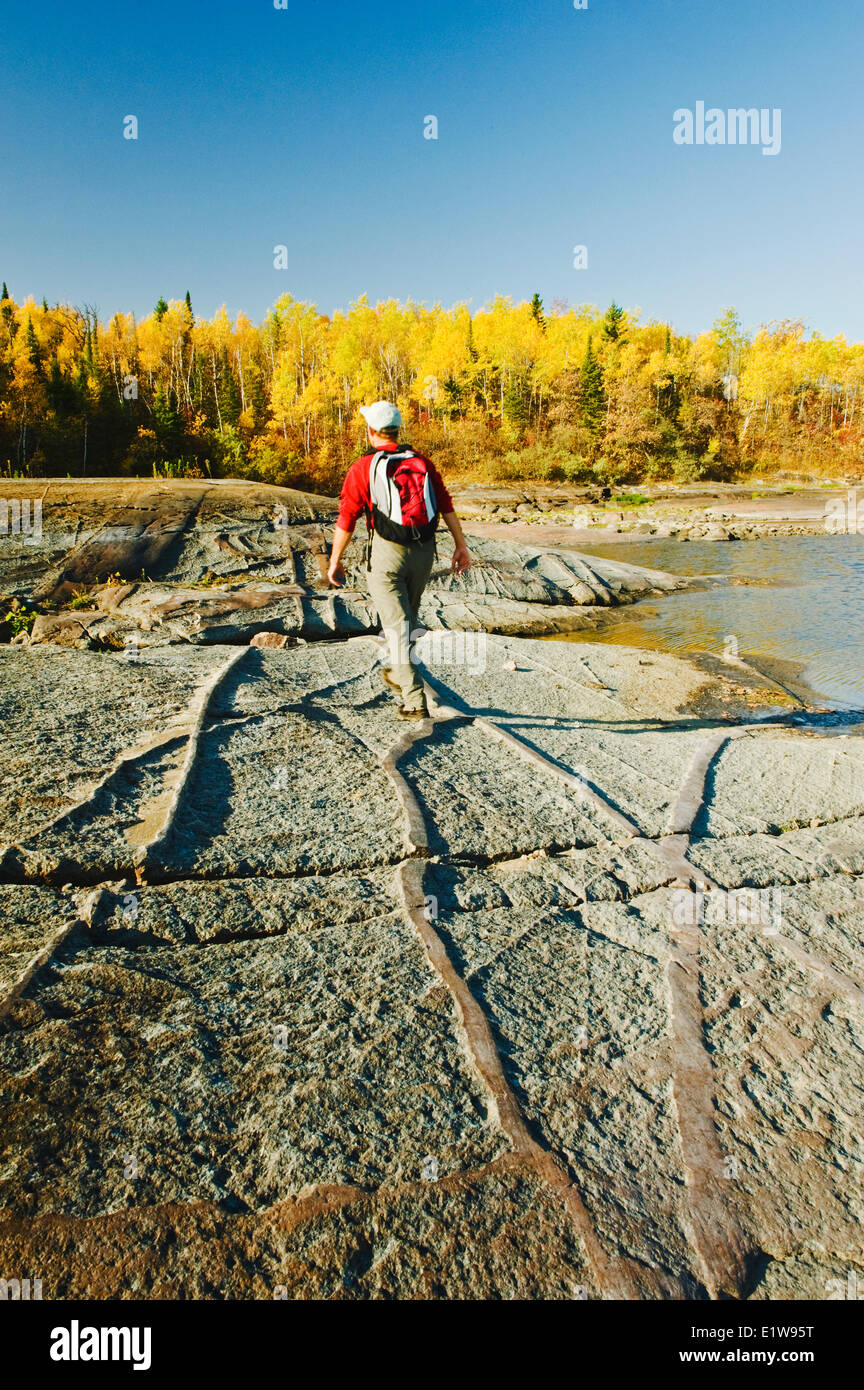 Hiking on precambrian shield rock along the Winnipeg River, near Seven ...
