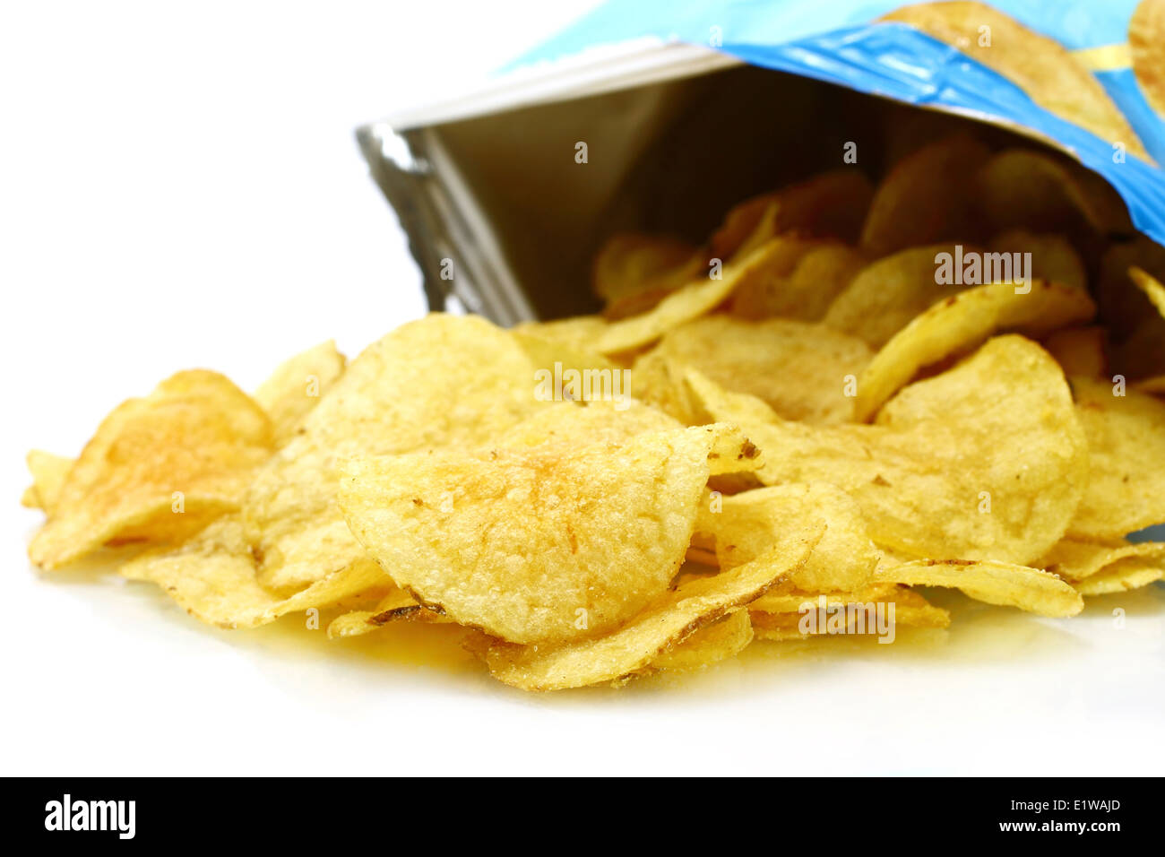 Potato chips poured out from packing on a white background Stock Photo ...