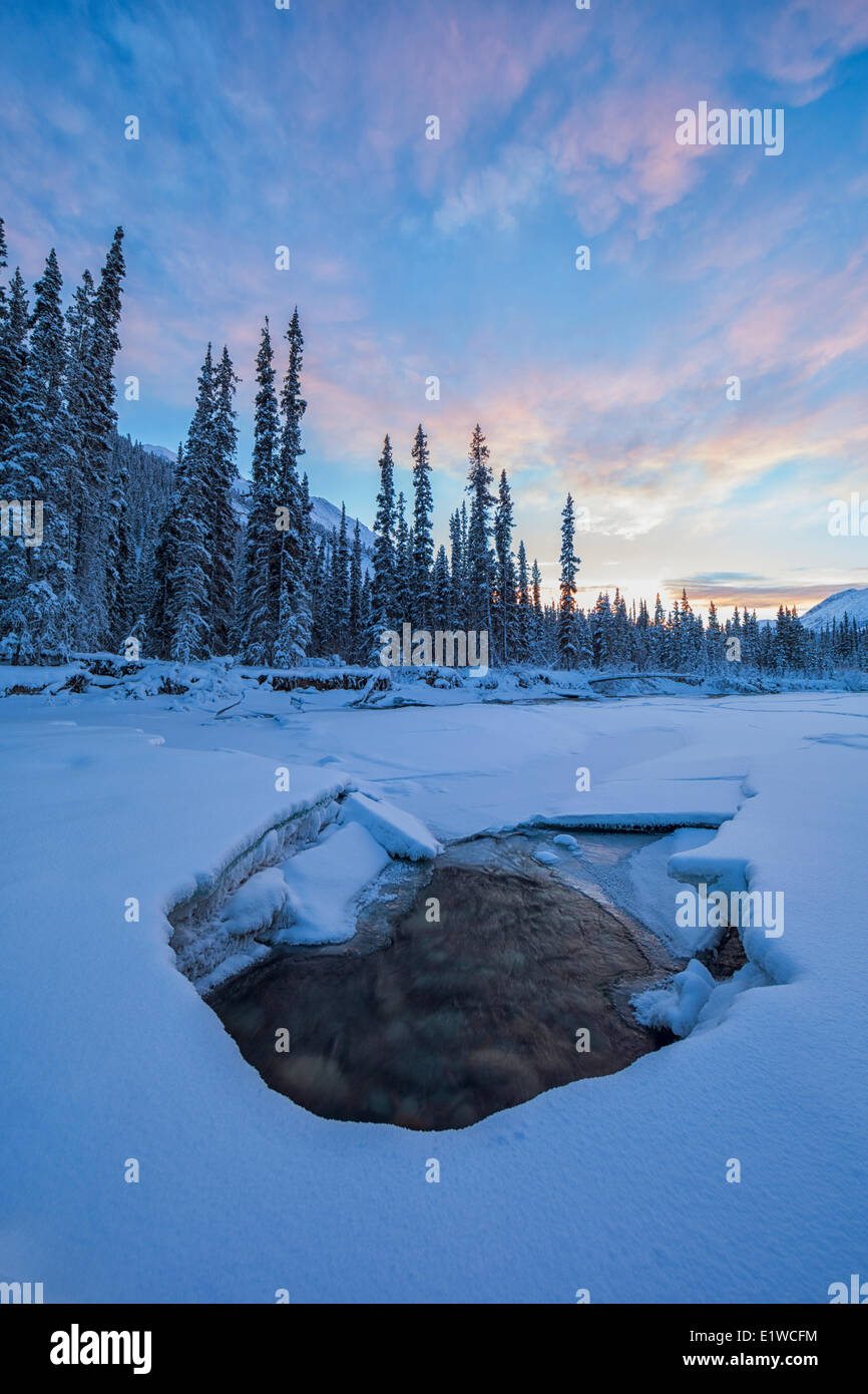 Sunset colours in the sky over the mostly frozen Wheaton River. The ...