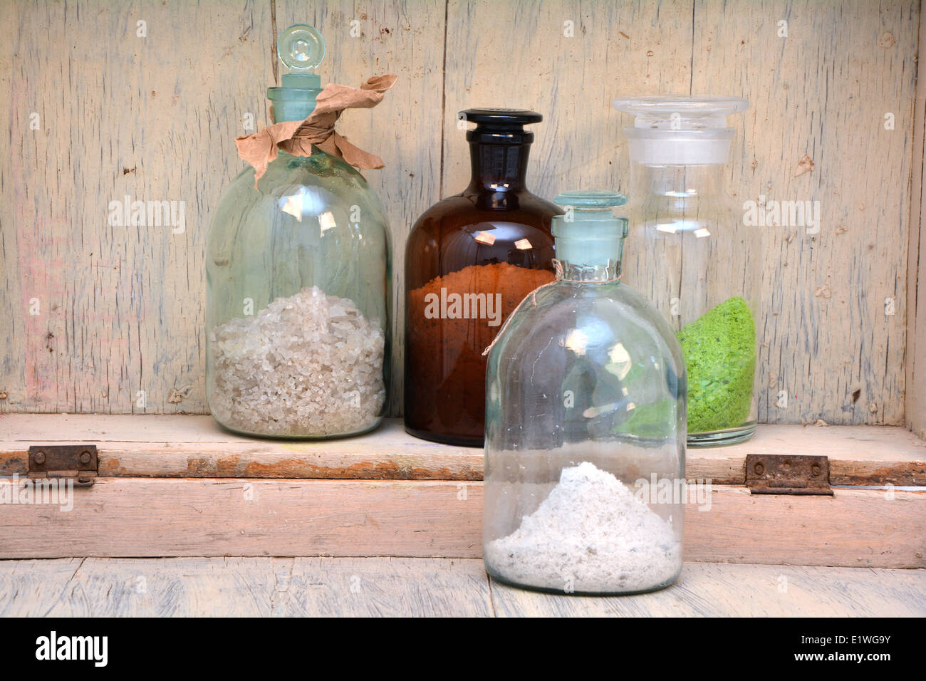 A set of chemical flasks with different chemical agents on an old shelf ...