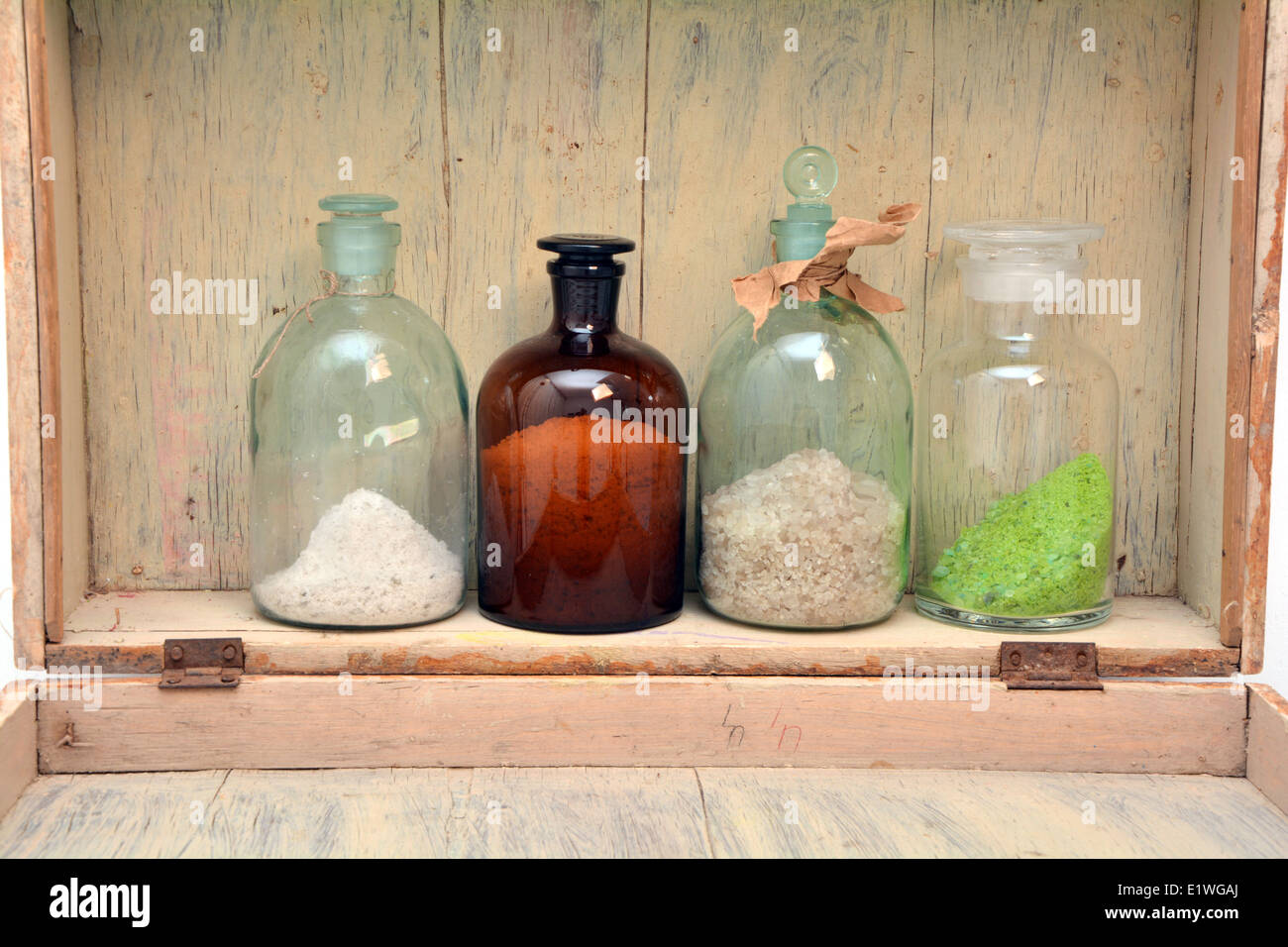 A set of chemical flasks with different chemical agents on an old shelf ...