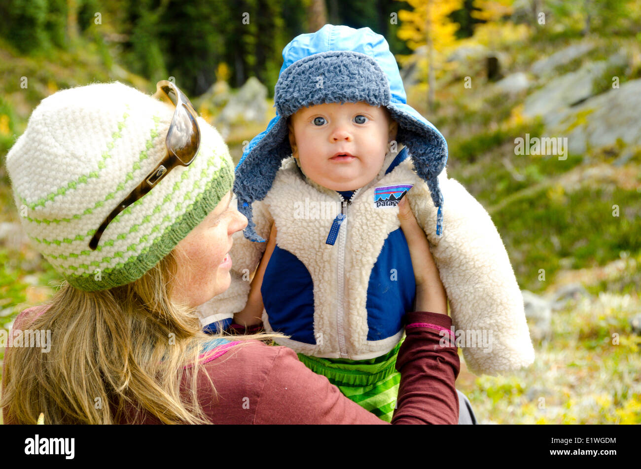 A boy is juggled by his mom while fall hiking in the Purcell Mountains ...
