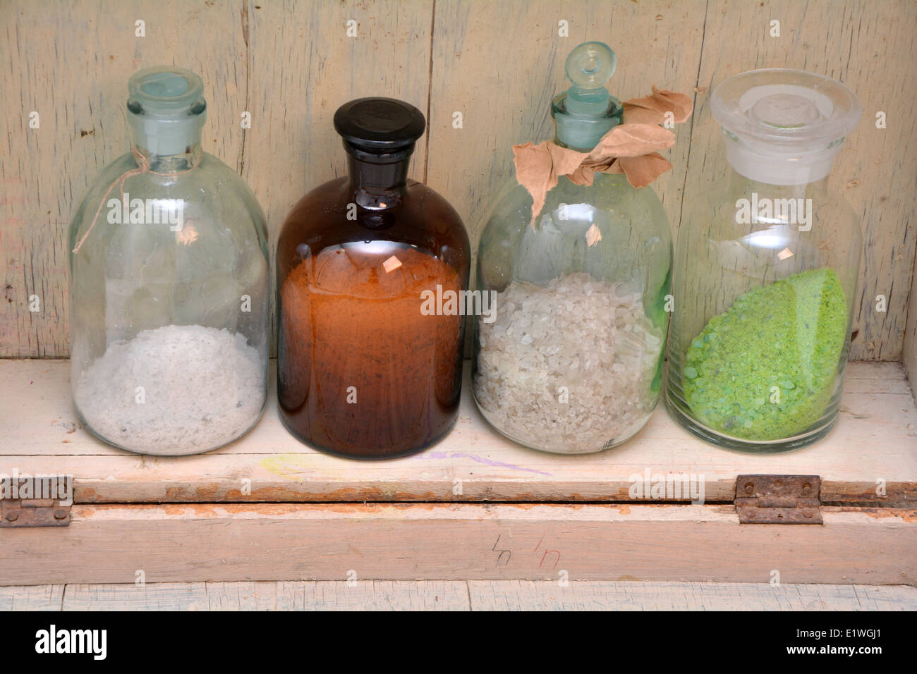 A set of chemical flasks with different chemical agents on an old shelf ...