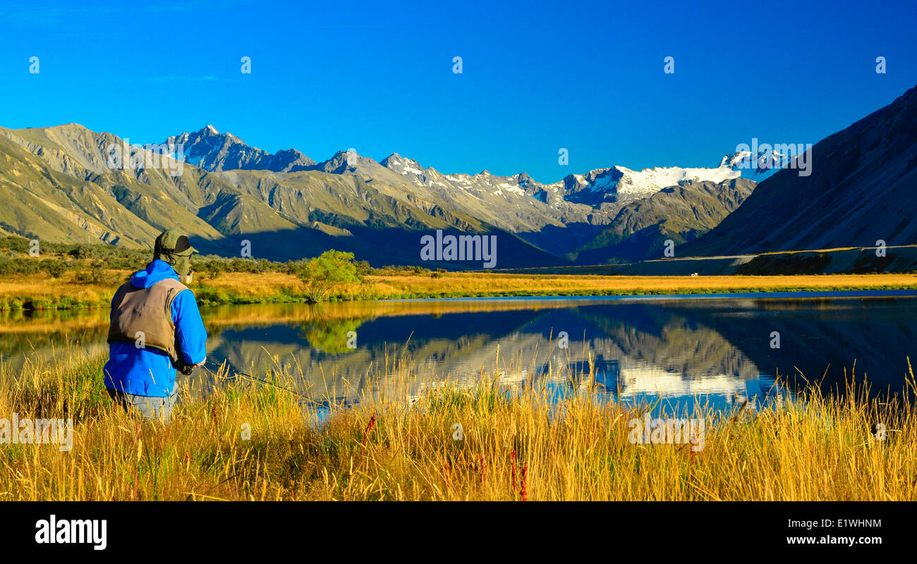 A man fly fishing on the shoreline, Horseshoe Tarn, Ahuriri Valley, New ...