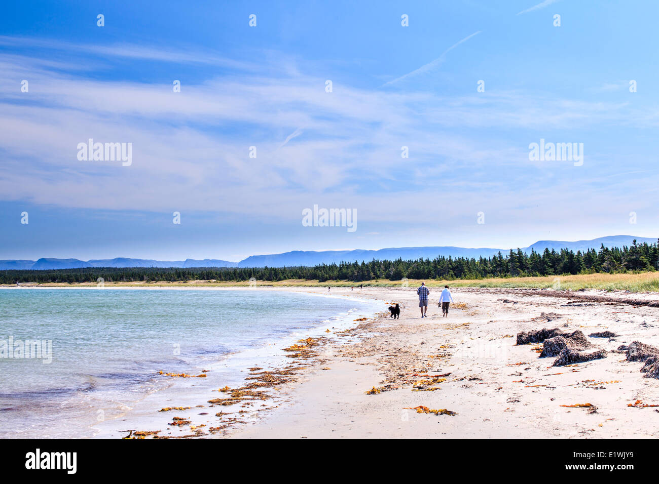 Male and female walk on the beach at shallow bay hi-res stock ...
