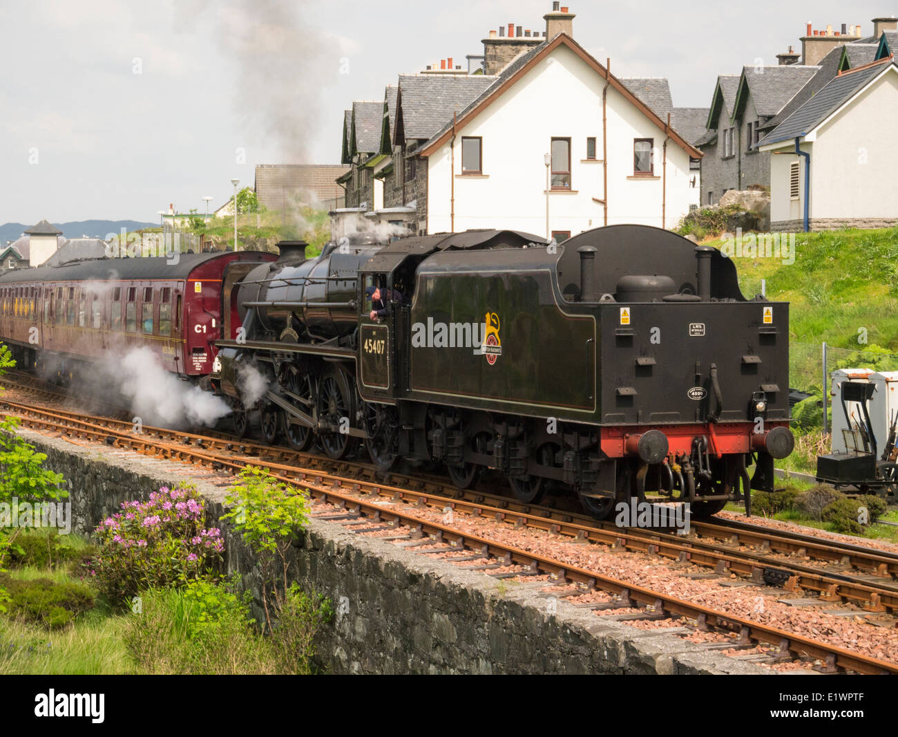 Jacobite steam train the Lancashire Fusilier leaving Mallaig village ...
