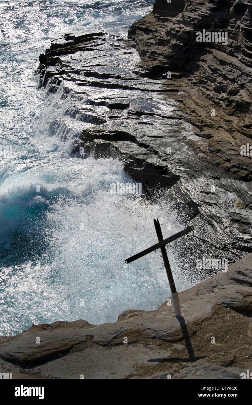 Cross at the point of a deadly accident on a dangerous cliff by ocean ...