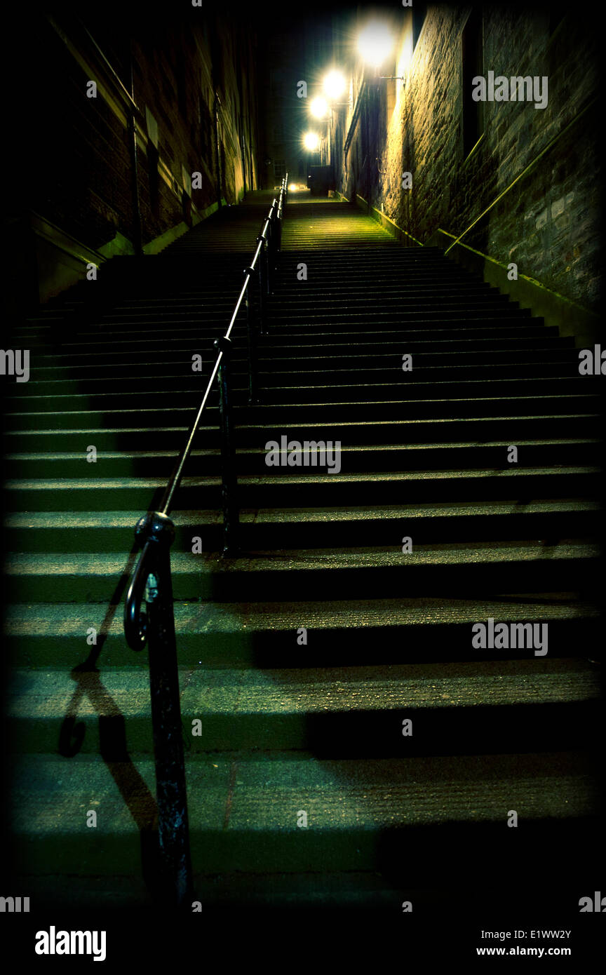 Dark street with uphill stairs illuminated at night in Edinbourgh ...