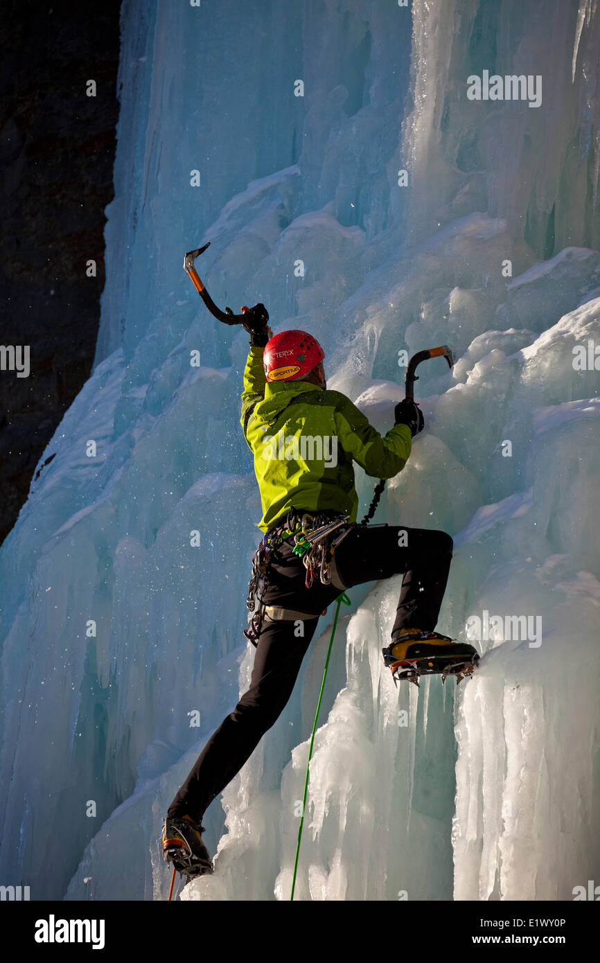 A male ice climber works his way the beautiful sunny ice climb called ...