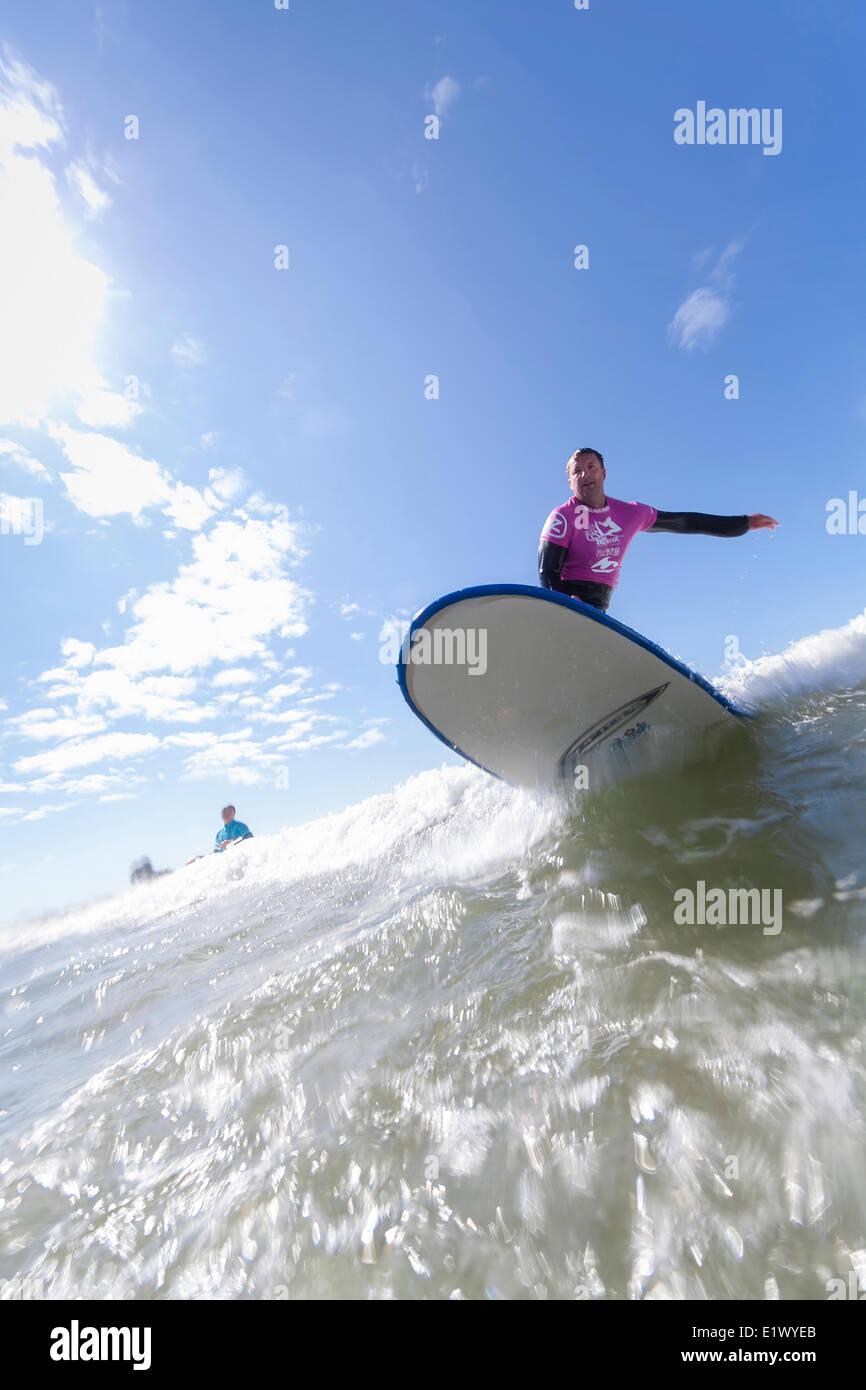 A beginning surfer rides a wave in at Chesterman Beach. Tofino ...