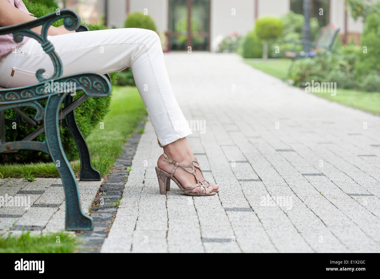 Low section of young woman sitting on park bench Stock Photo - Alamy
