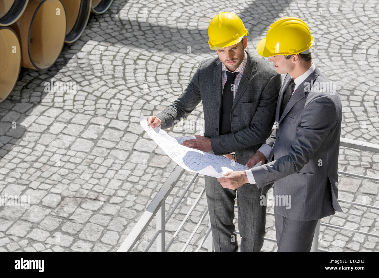 High angle view of young male architects examining blueprint by ...