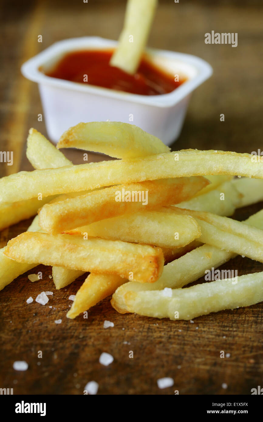 Traditional potatoes French fries with salt on wooden background Stock ...