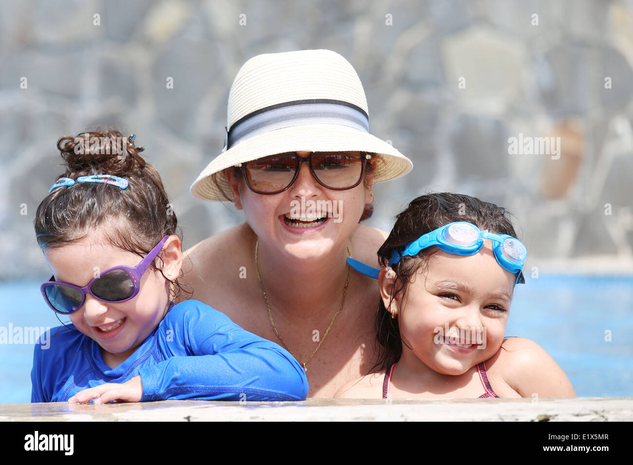 Happy mother with her kids in the pool Stock Photo - Alamy