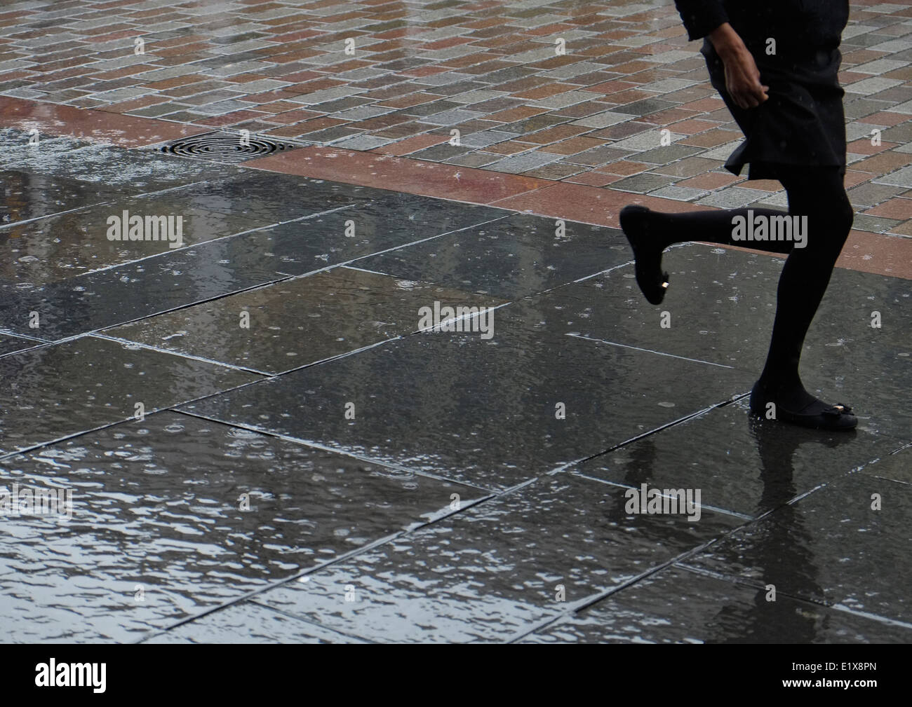 A young woman runs through the rain and out of the image Stock Photo ...