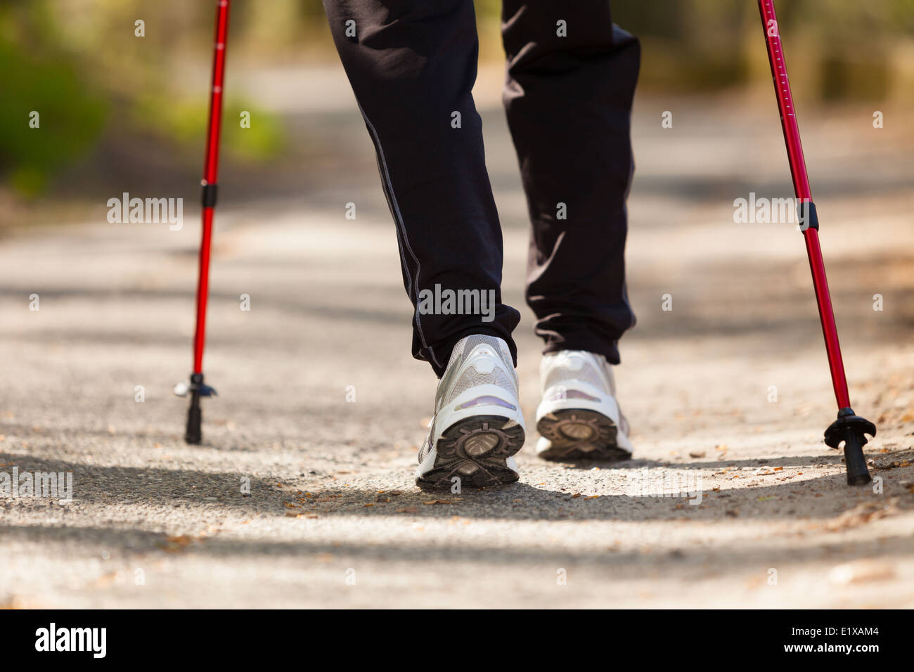 Nordic walking. Female legs hiking in the park Stock Photo - Alamy