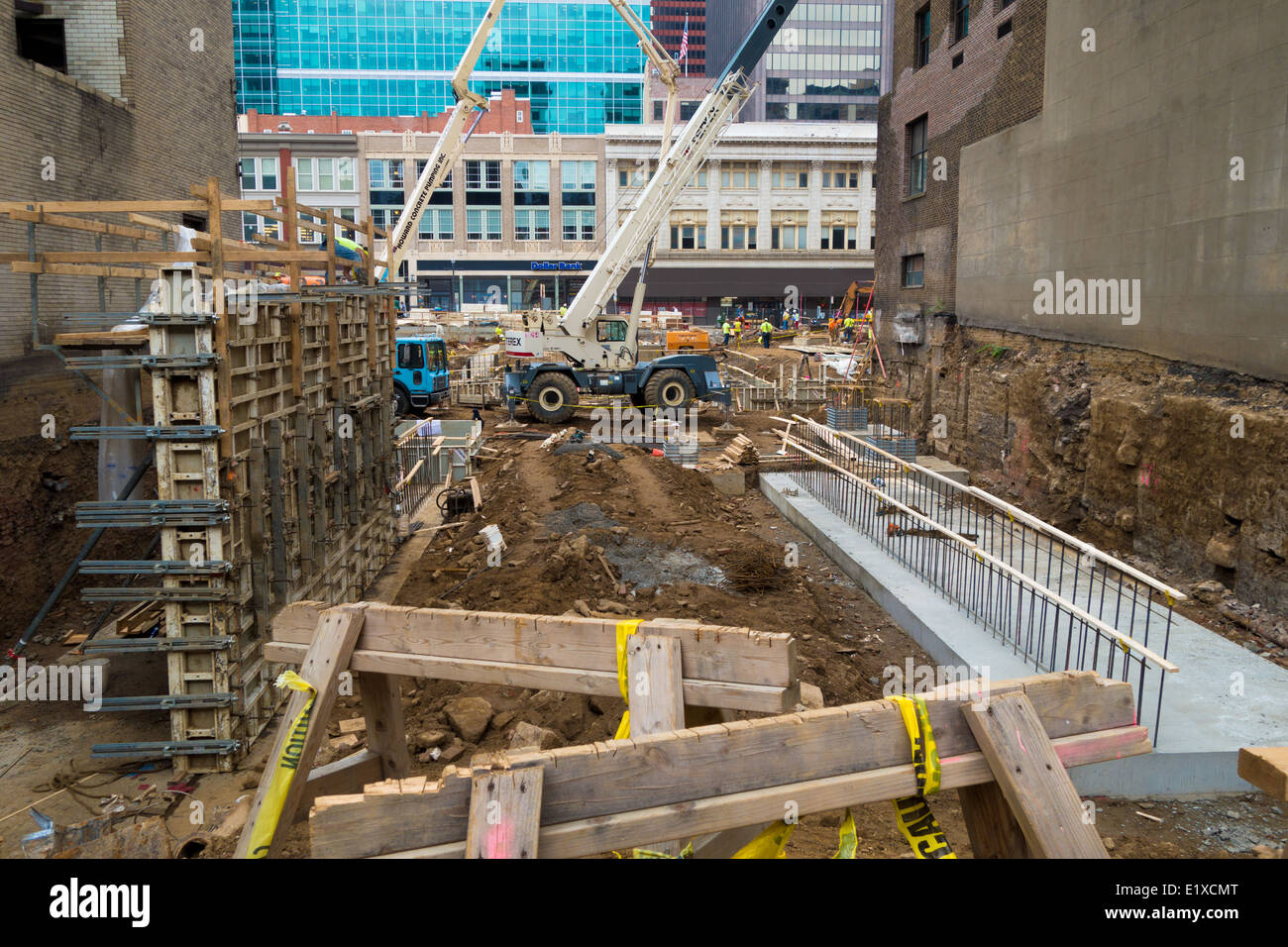 A construction site that has been dug up sits amidst buildings in ...