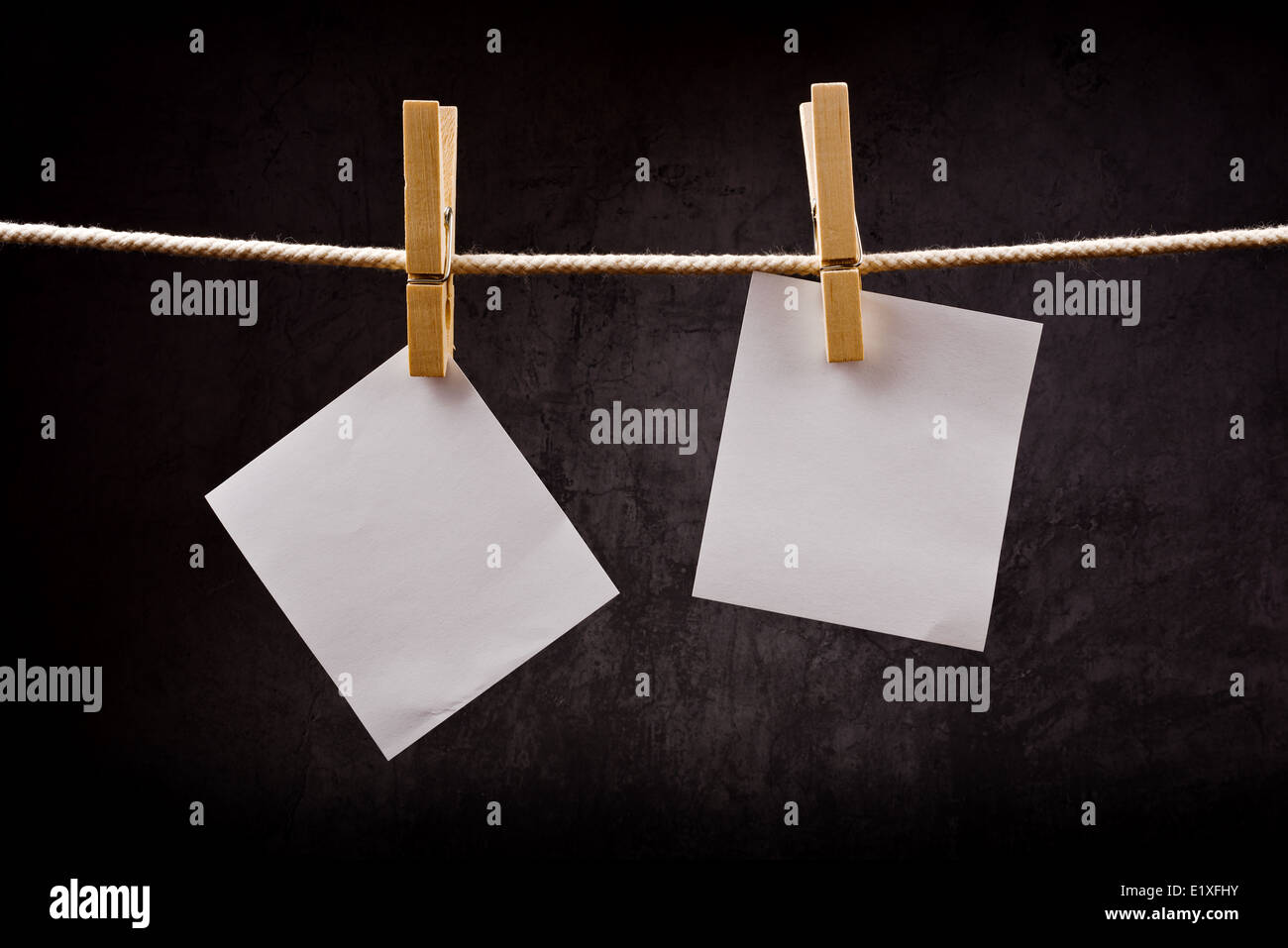 Two Blank paper notes hanging on rope with clothes pins, copy space for ...