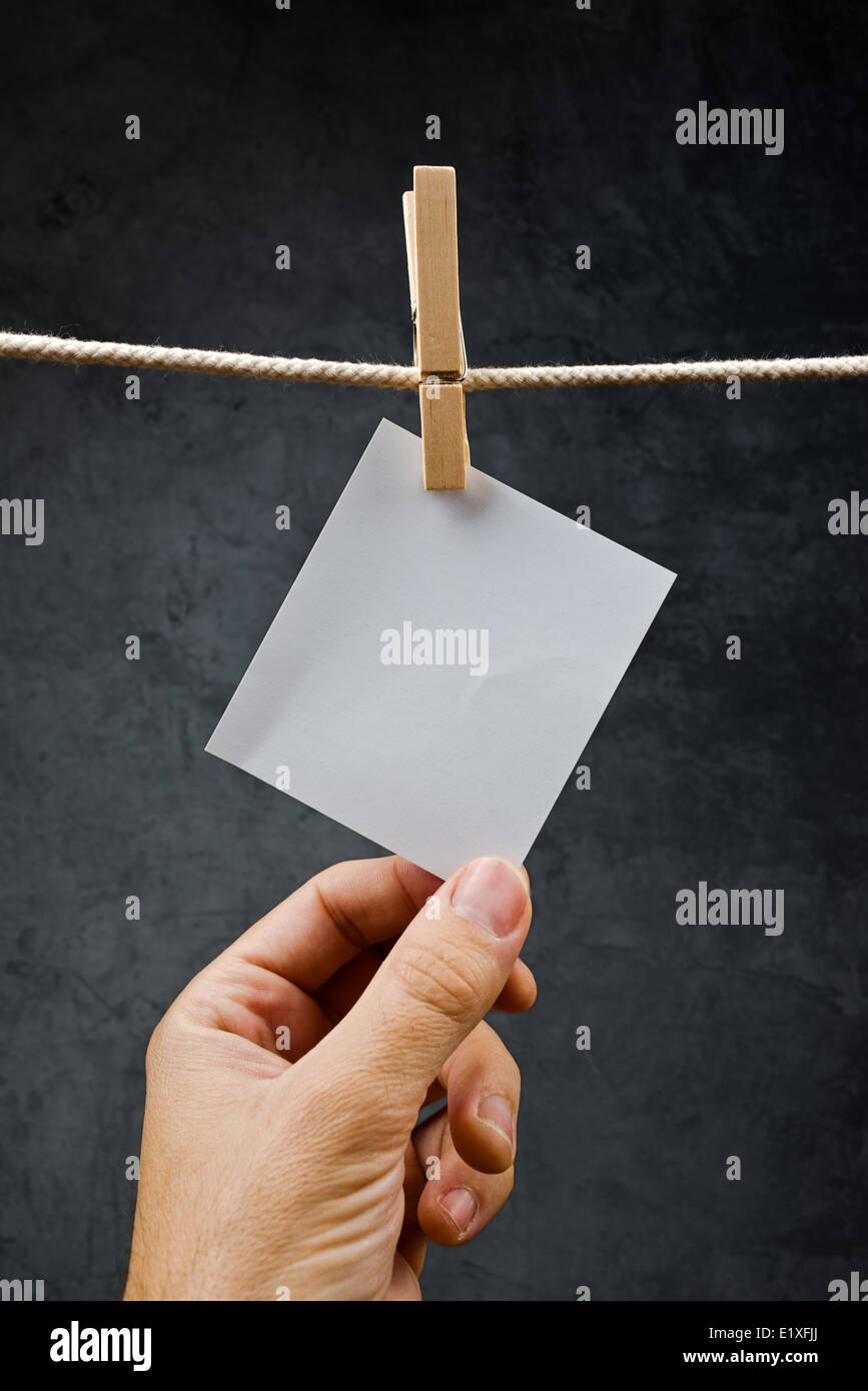 Hand picking Blank note paper attached to rope with clothes pins, copy ...