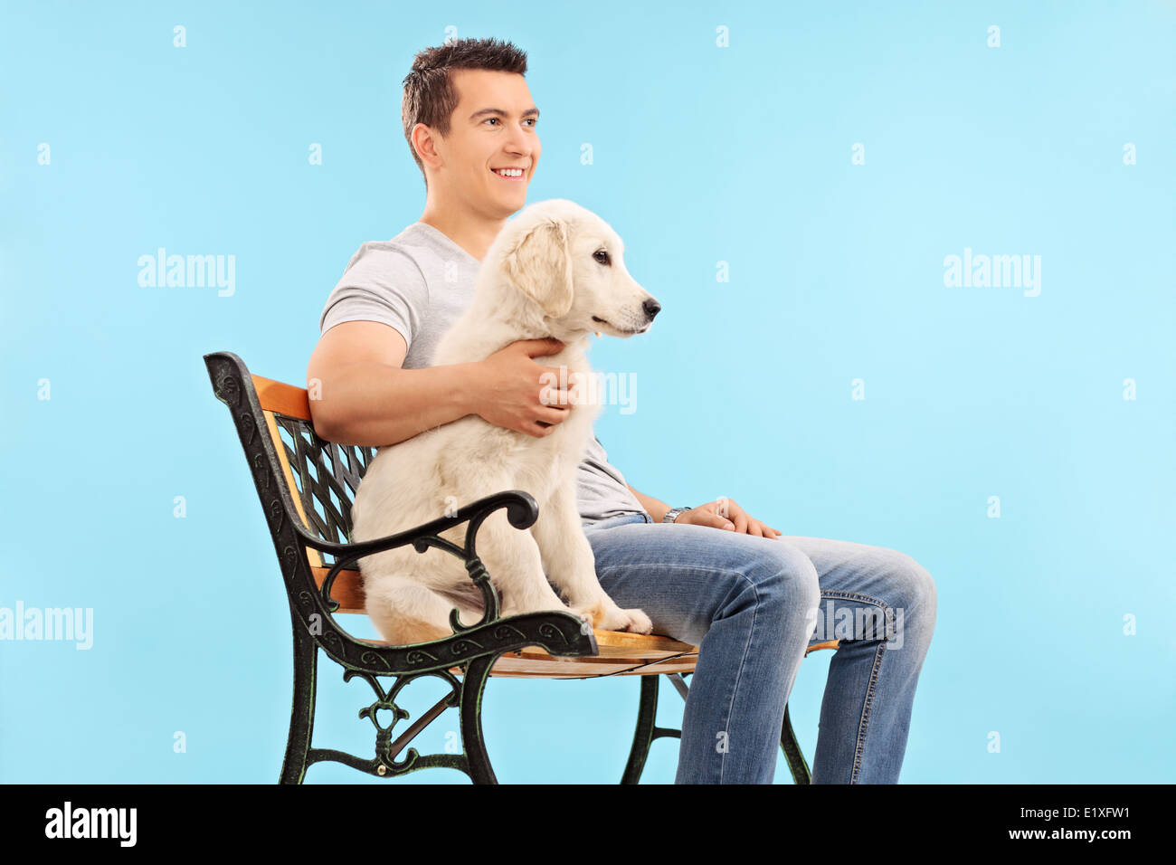 Man sitting on bench with a young dog Stock Photo - Alamy