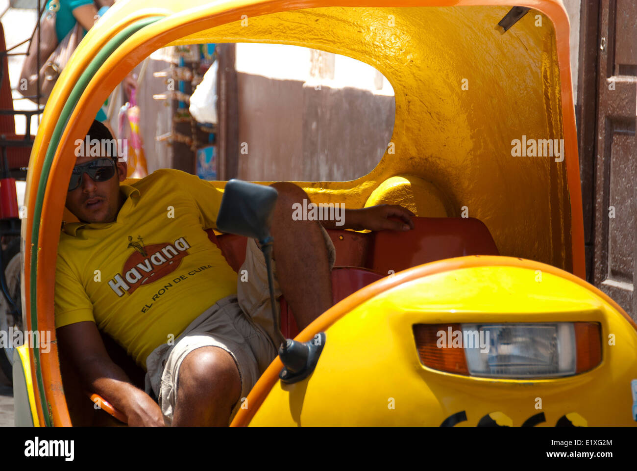 Coco taxi driver sleeping in his yellow coco taxi in Havana, Cuba Stock ...