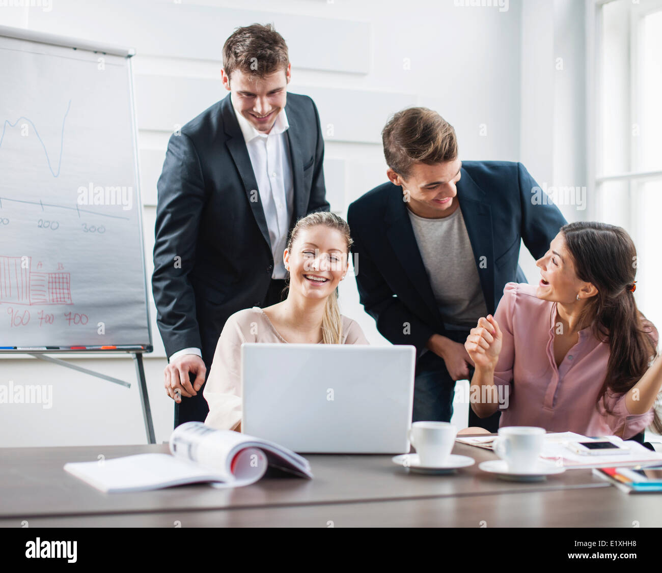 Successful young business people using laptop at desk in office Stock ...