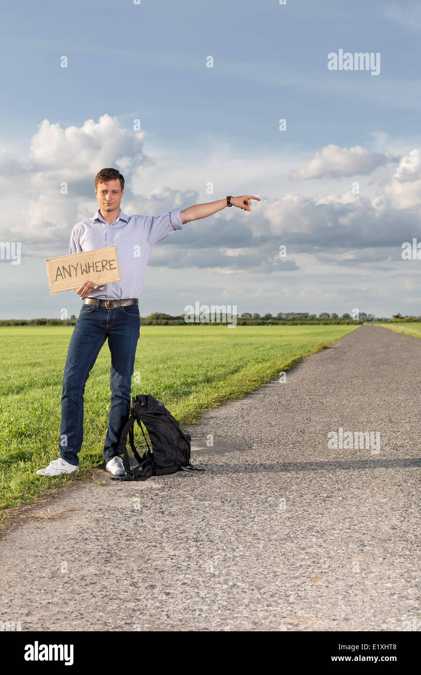Full length portrait of young man with anywhere sign gesturing on ...