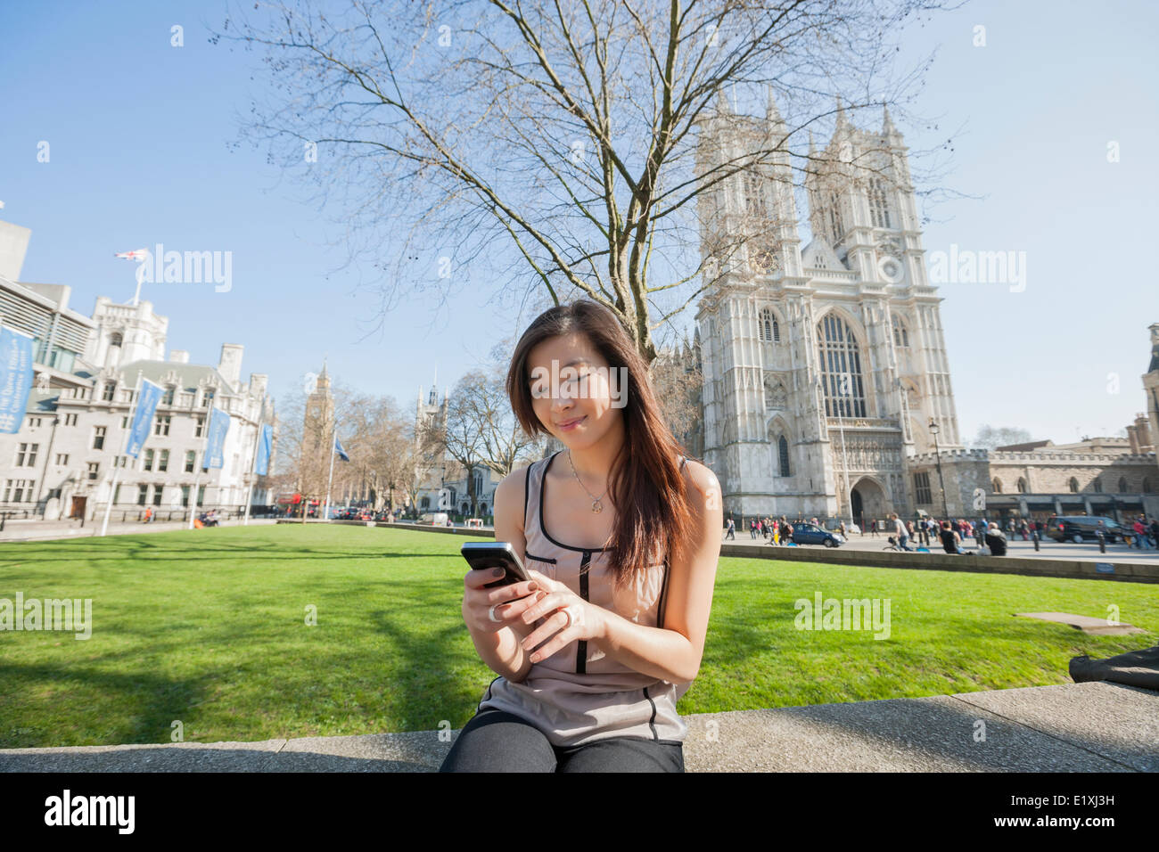 Young woman using cell phone against Westminster Abbey in London ...