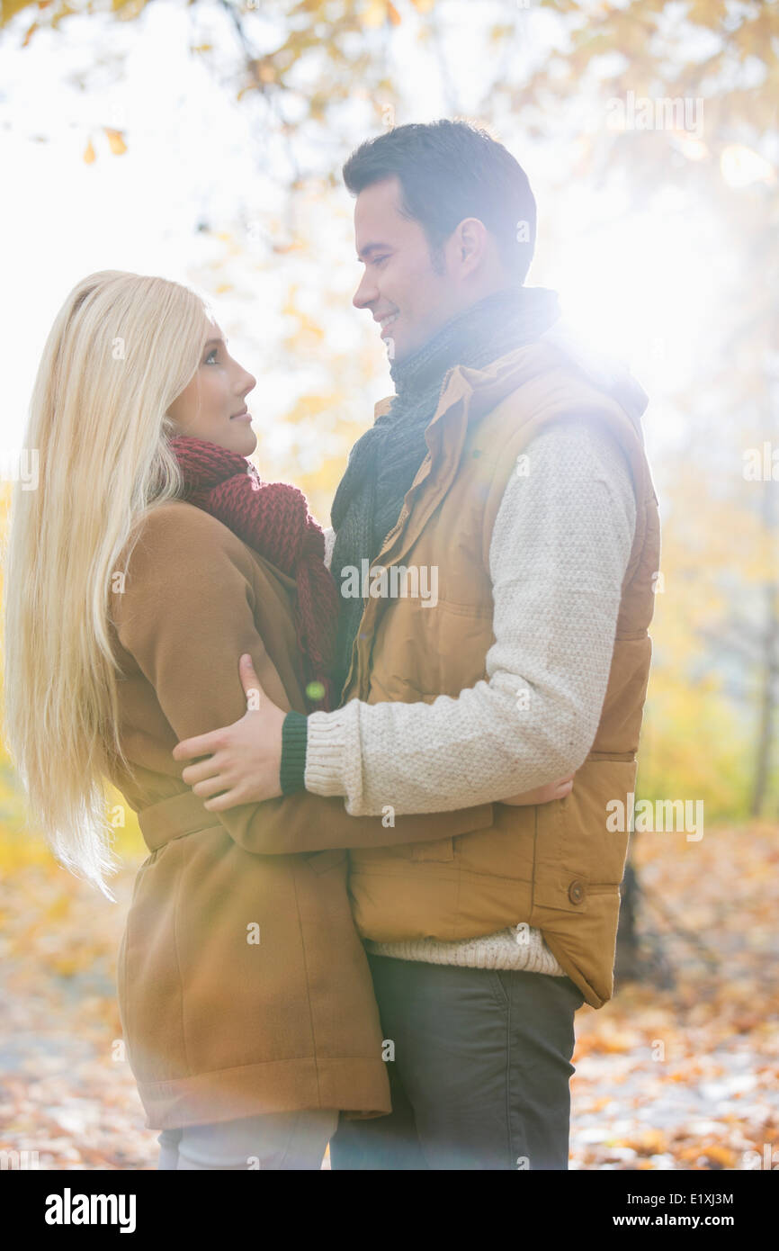 Side view of couple hugging in park Stock Photo - Alamy