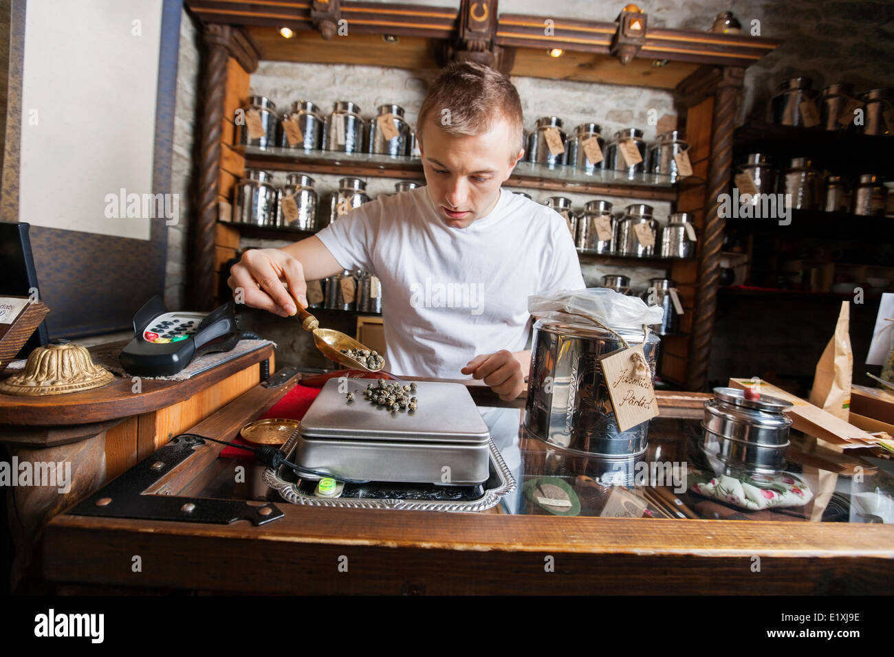 Male owner measuring ingredient on weight scale in tea store Stock ...