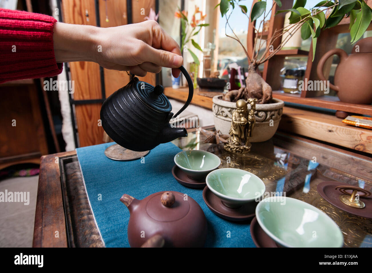 Male hand pouring tea into tea cups in store Stock Photo - Alamy