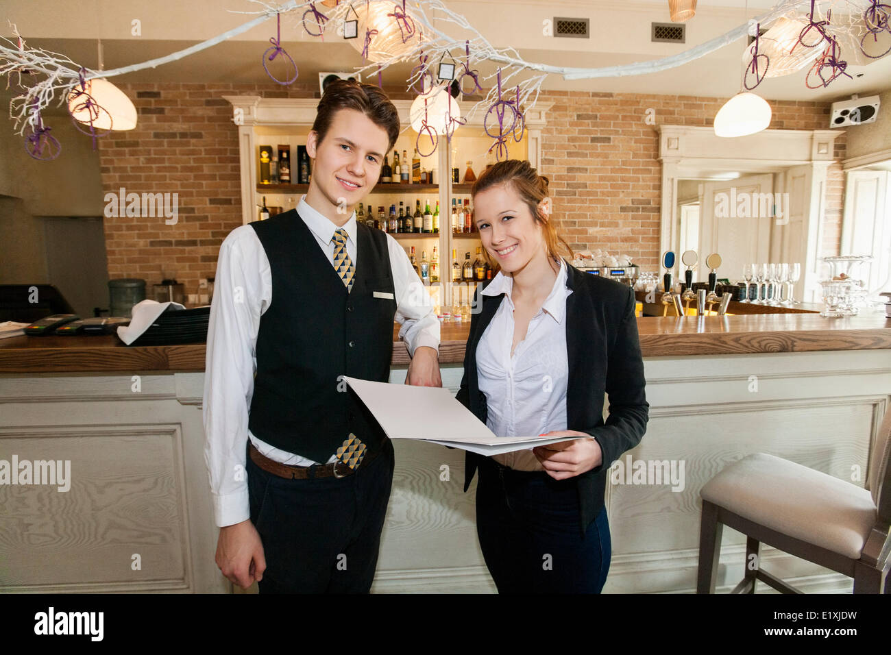 Portrait of happy waiter and waitress in restaurant Stock Photo - Alamy