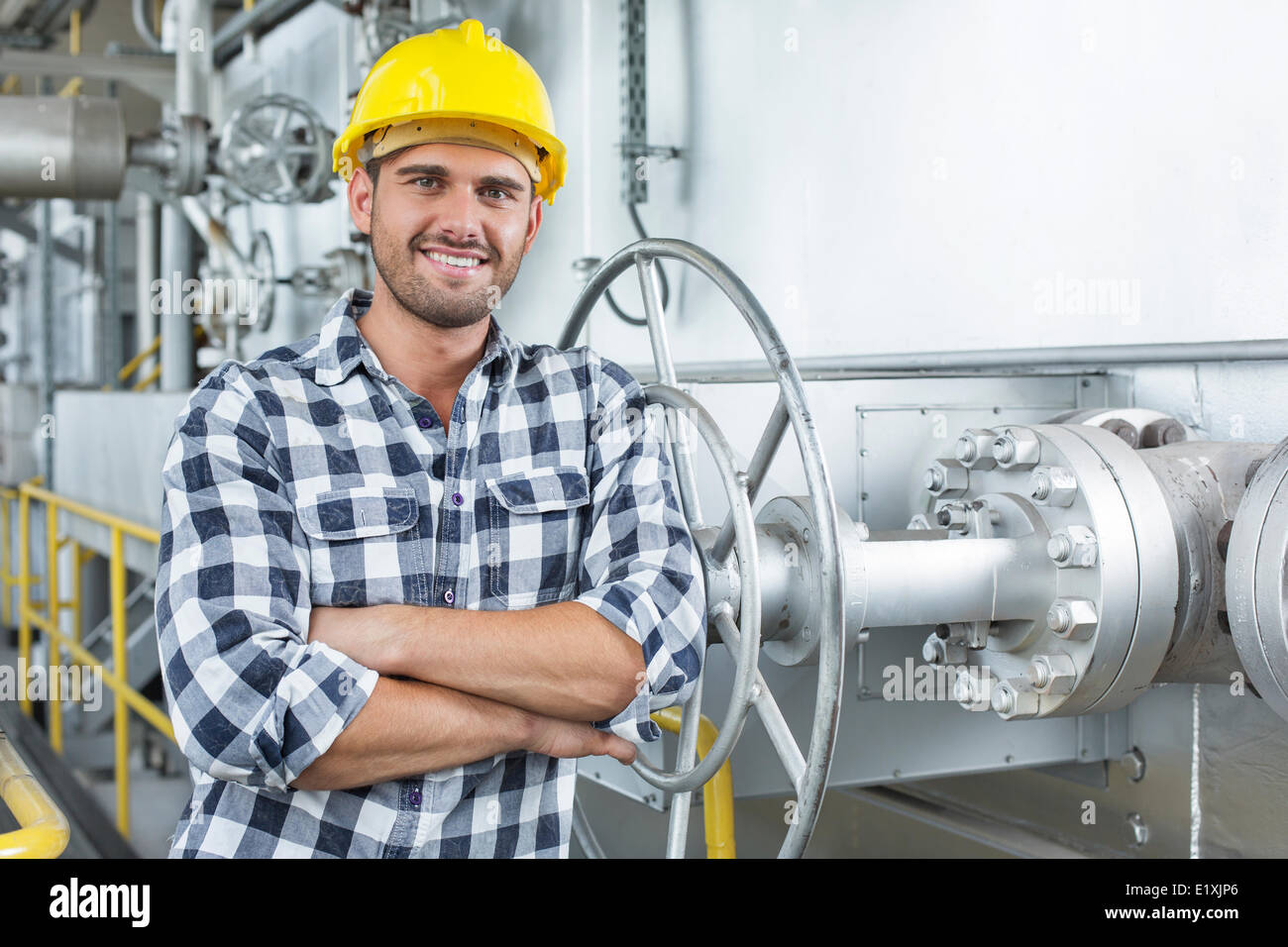 Young male worker standing arms crossed in industry Stock Photo - Alamy