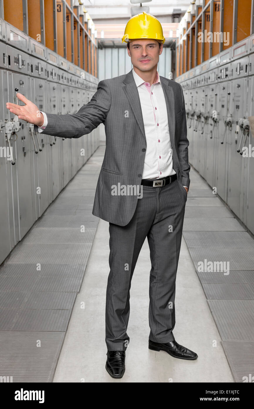 Full length portrait of confident young male inspector gesturing in ...