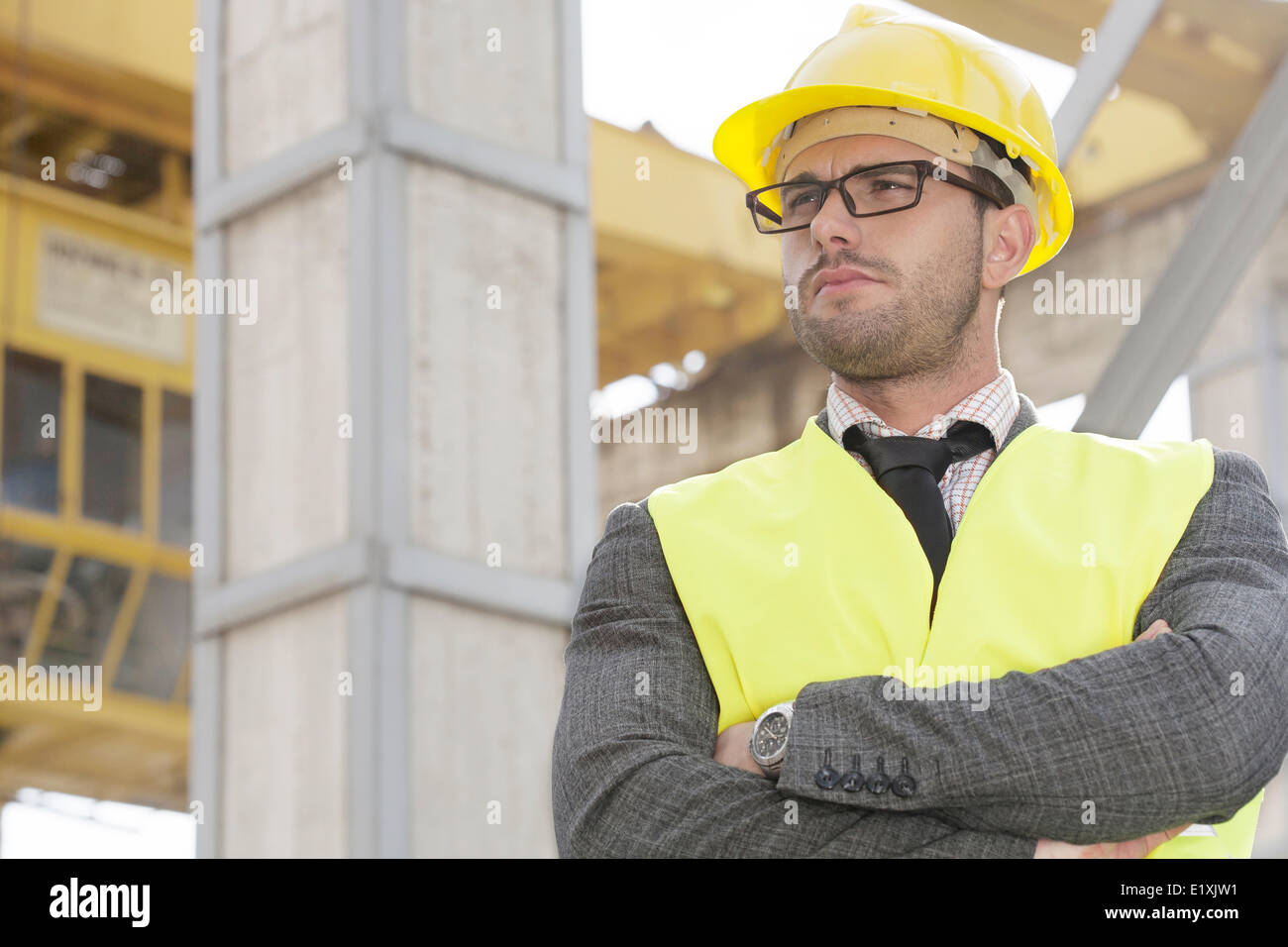 Young male architect standing arms crossed at construction site Stock ...