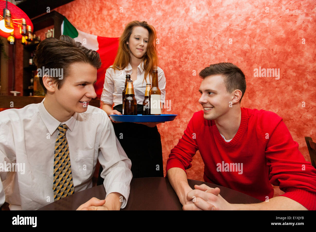 Waitress serving drinks to men in restaurant Stock Photo - Alamy