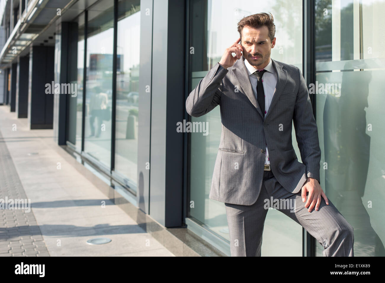 Young businessman using mobile phone outside office Stock Photo - Alamy