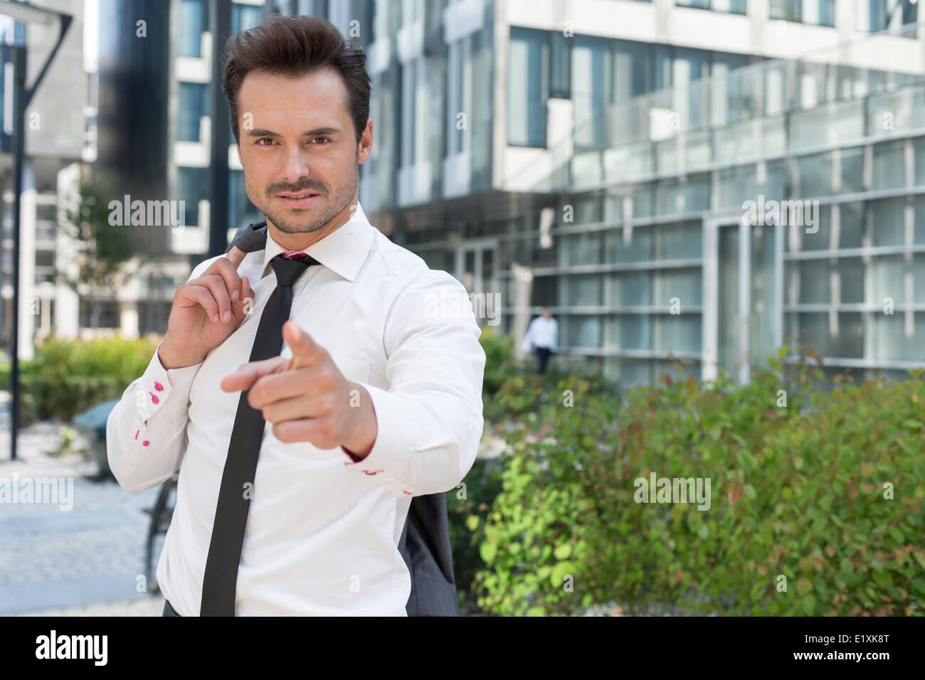 Portrait of angry businessman pointing at you outside office building ...