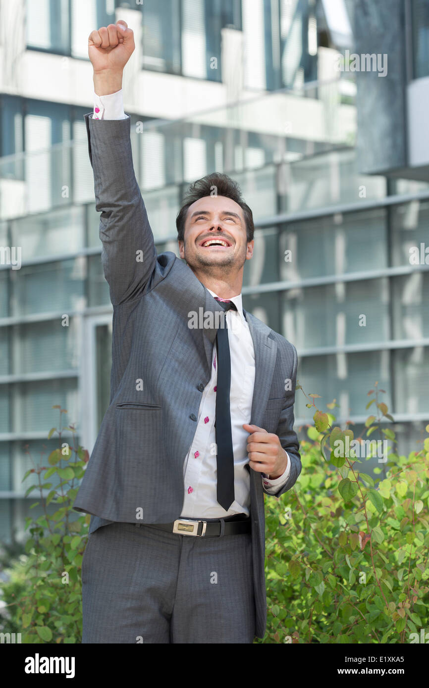 Excited businessman celebrating success outside office building Stock ...