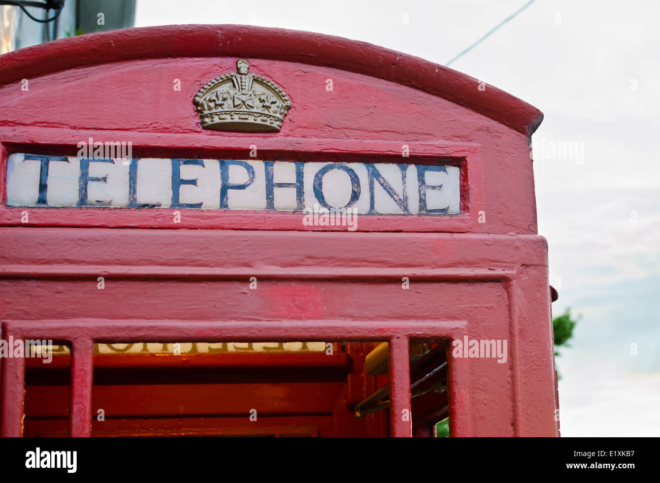 Closeup of British red telephone booth showing telephone sign and royal ...