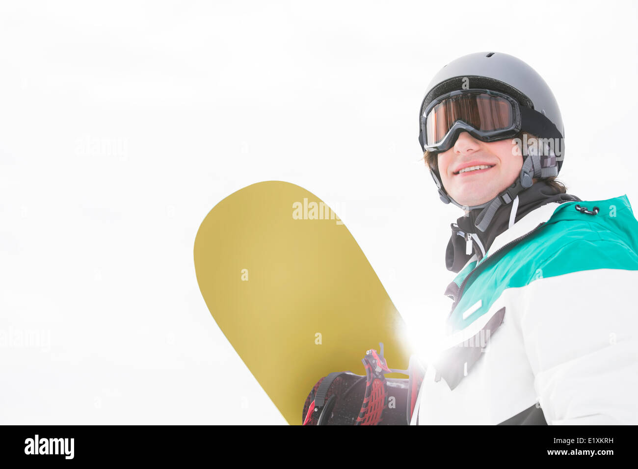 Smiling young man holding snowboard against clear sky Stock Photo - Alamy