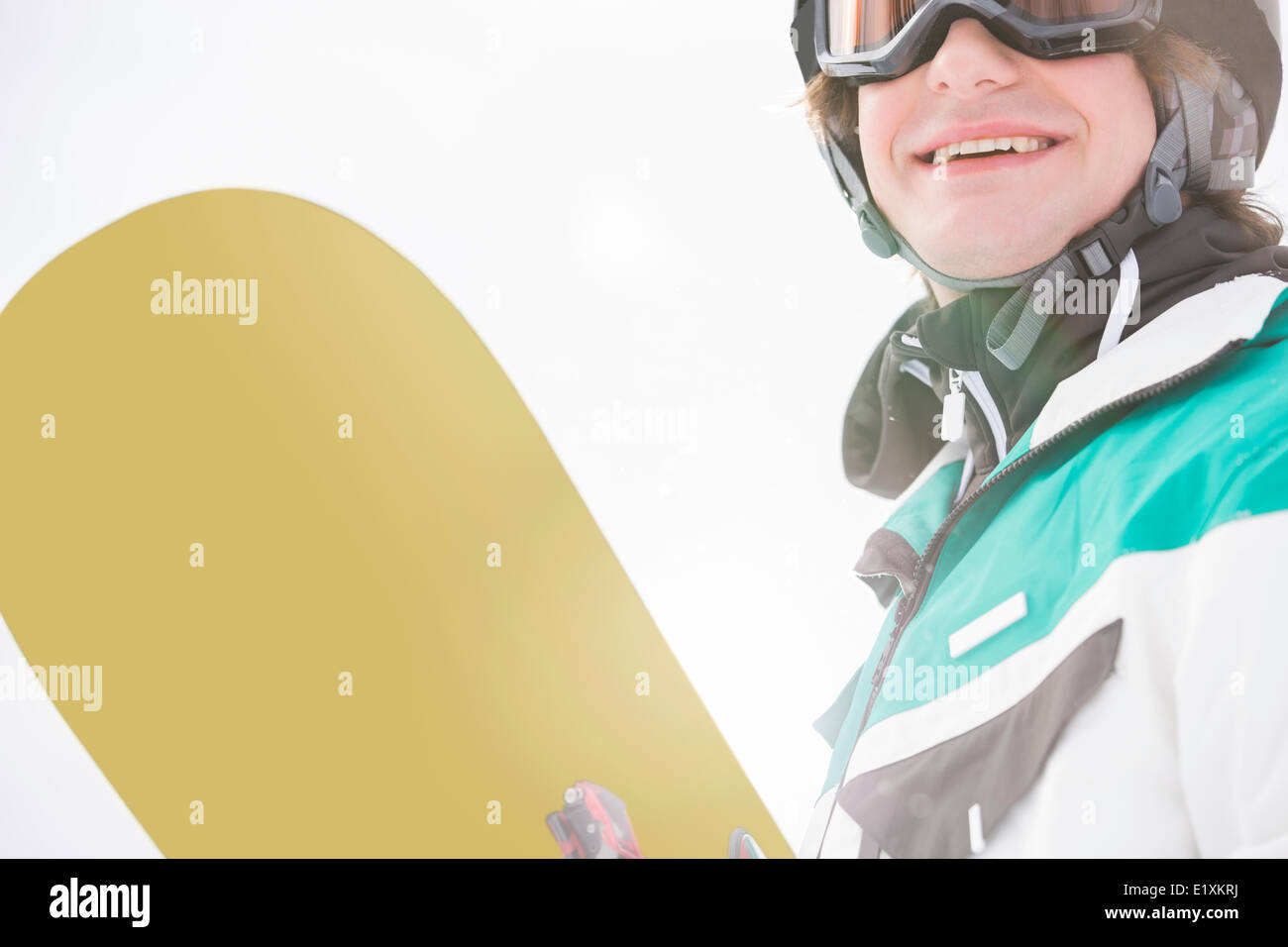 Smiling young man holding snowboard Stock Photo - Alamy