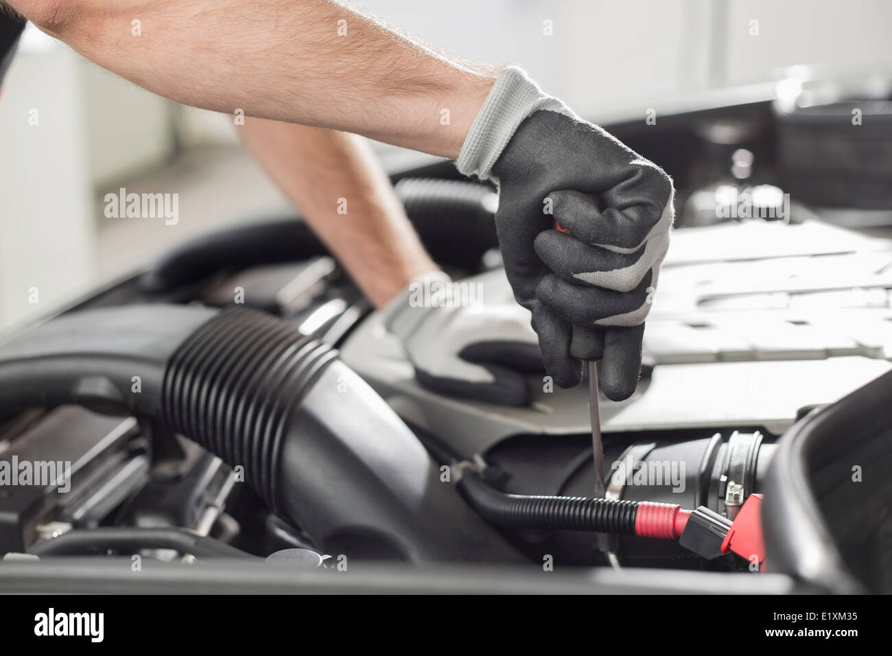 Cropped image of automobile mechanic repairing car in automobile store ...