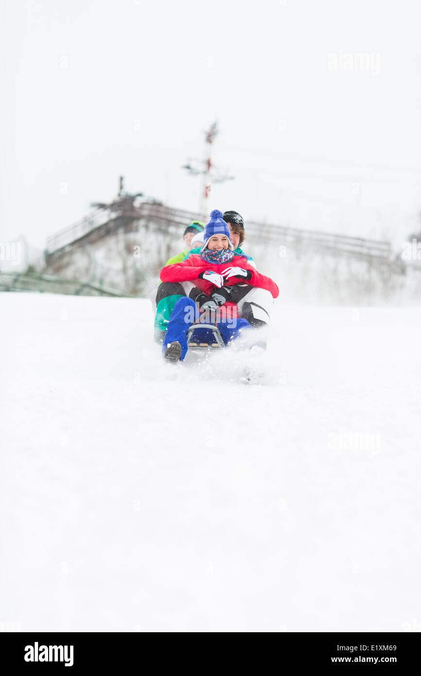 Group of friends enjoying sled ride in snow Stock Photo - Alamy