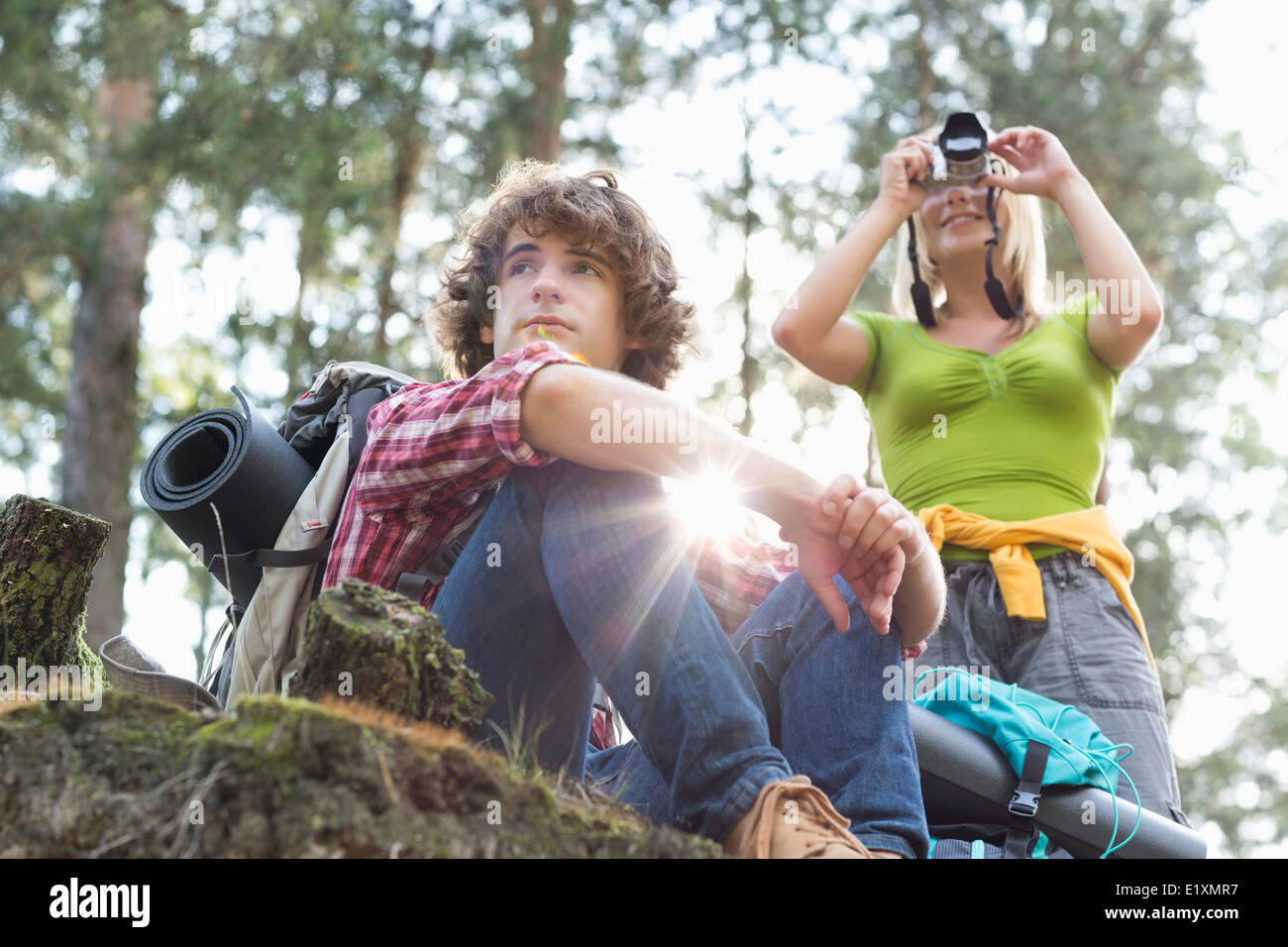 Young female hiker photographing through digital camera while man ...