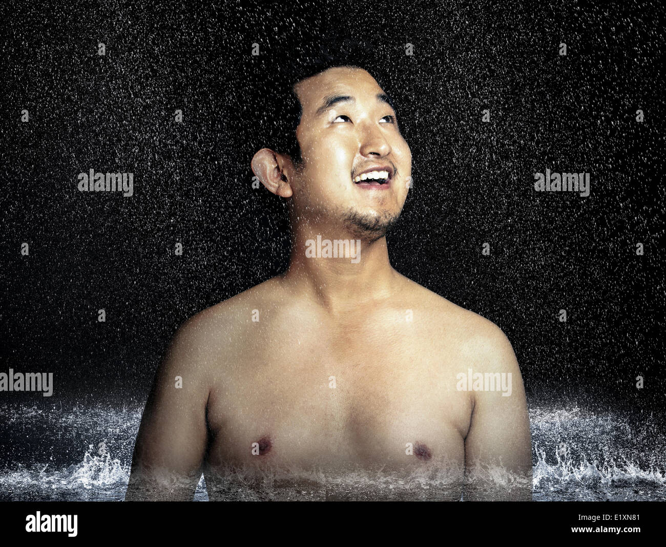 Shirtless young man enjoying rain Stock Photo - Alamy