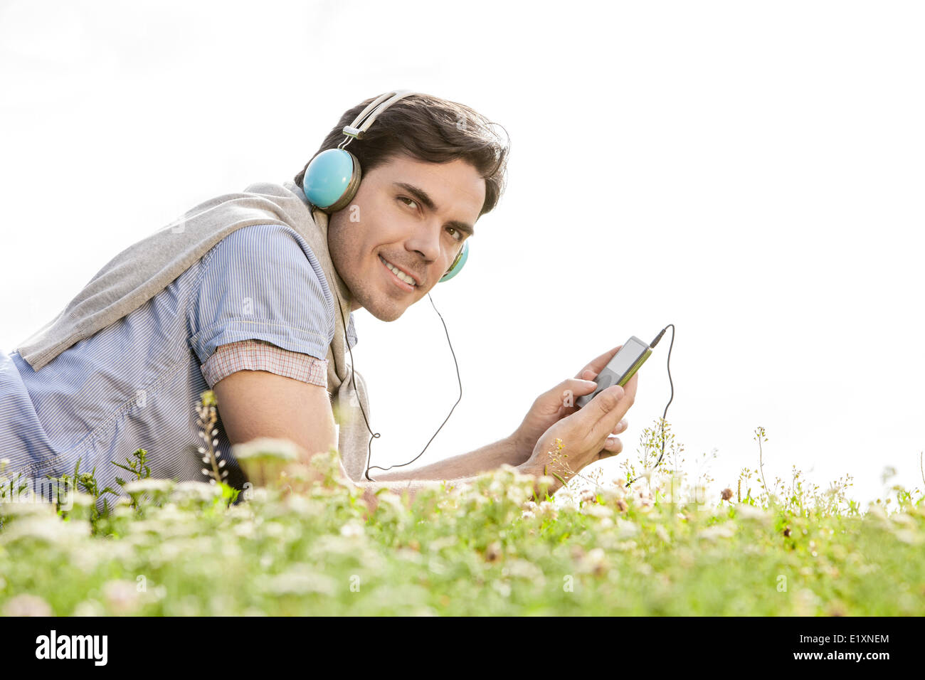 Side view portrait of man listening to music on MP3 player using ...