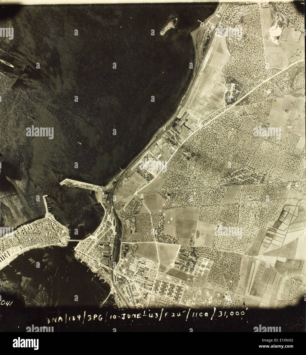 This reconnaissance aerial photograph captures the coastal city of ...