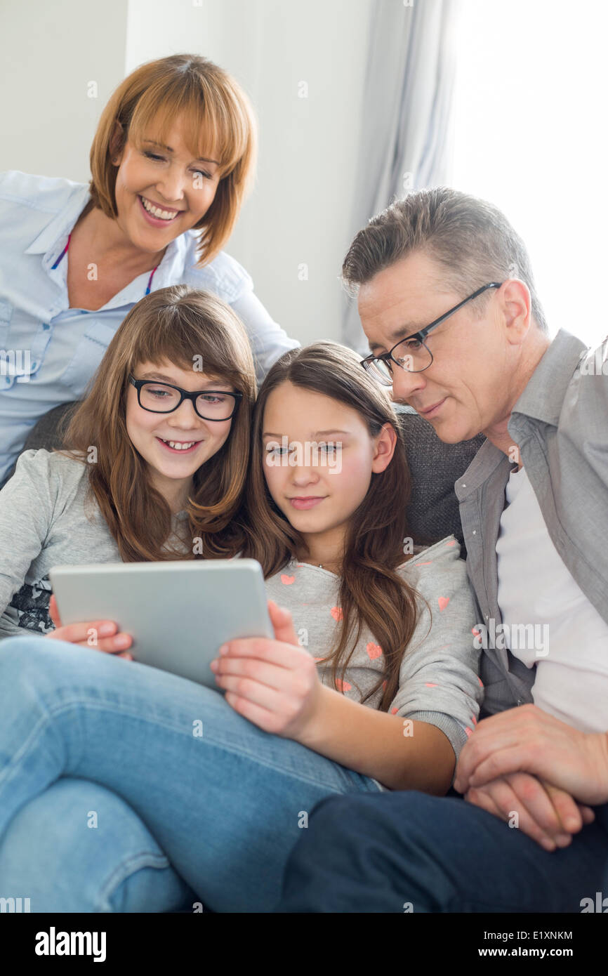 Family using digital tablet together in living room Stock Photo - Alamy