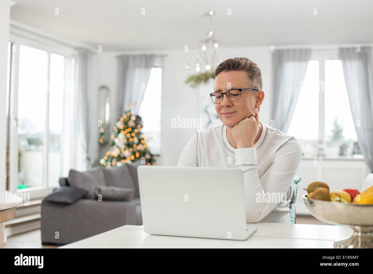 Smiling man using laptop at home Stock Photo - Alamy